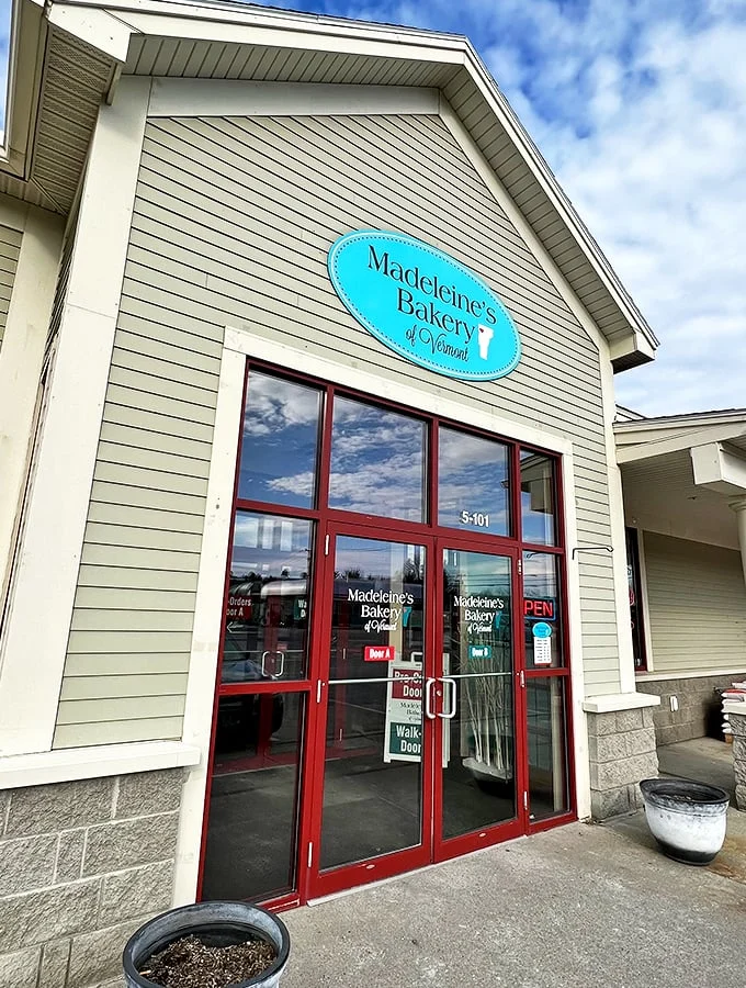 Welcome to carb heaven! Madeleine's Bakery stands like a beacon of buttery hope, its blue sign a siren call to sweet-toothed wanderers.