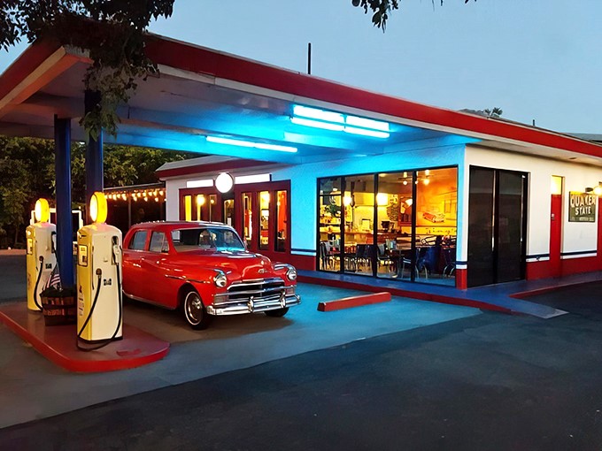 Step back in time! This neon-lit oasis isn't just serving burgers – it's dishing out a heaping helping of 1950s nostalgia, complete with a cherry-red classic car.