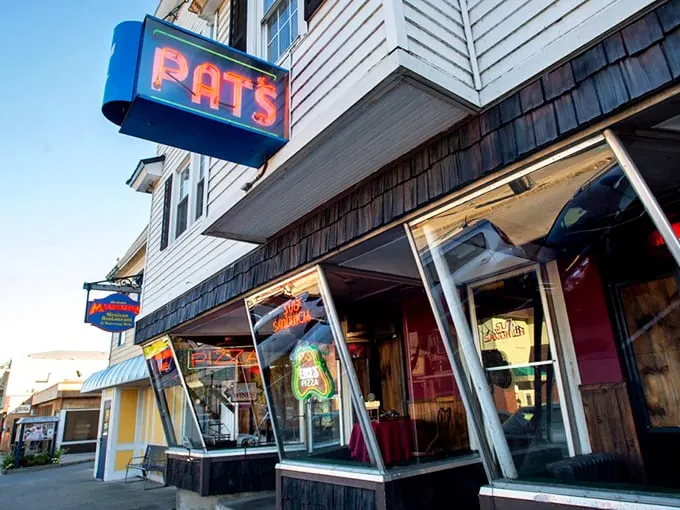 Neon dreams and pizza schemes! Pat's iconic sign beckons like a lighthouse for the hungry, promising a slice of Orono history with every bite.