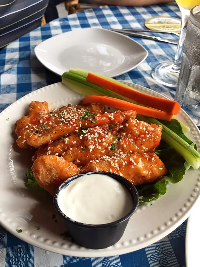 Crispy wings glazed with sweet-spicy sauce and sesame seeds, served with fresh vegetables and cooling ranch. Photo credit: Karen S.