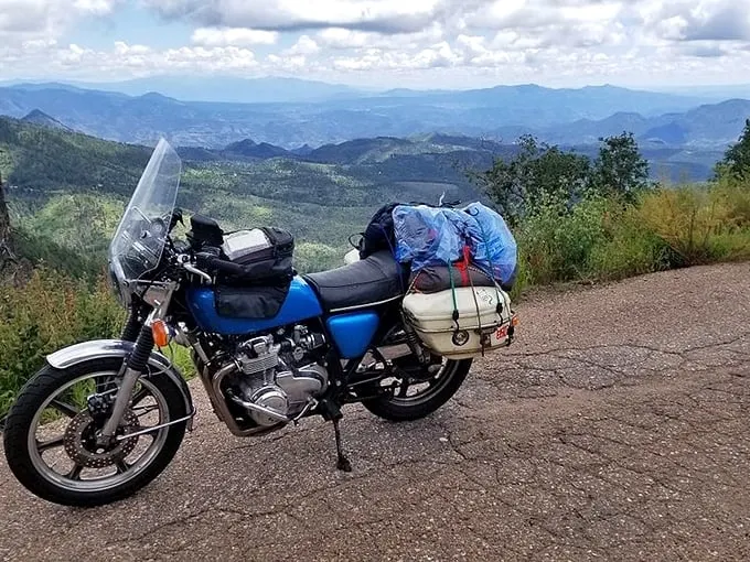 A lone motorcycle takes a breather at the overlook, its rider clearly understanding the art of the perfect road trip.