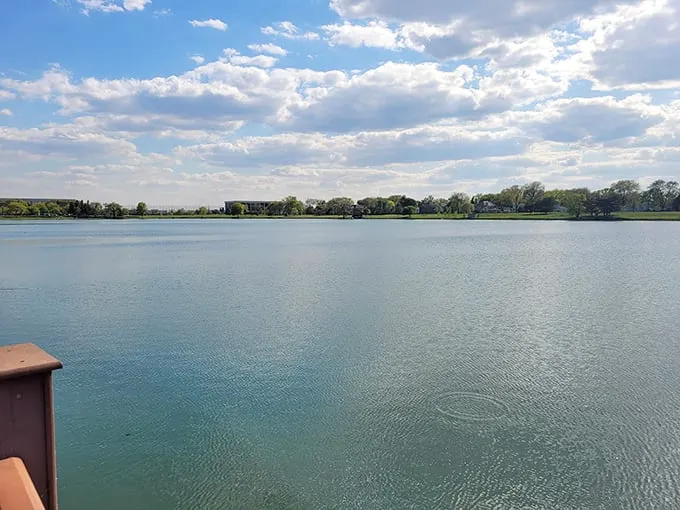 The lake stretches out like nature's mirror, reflecting clouds that seem to dance across its surface.