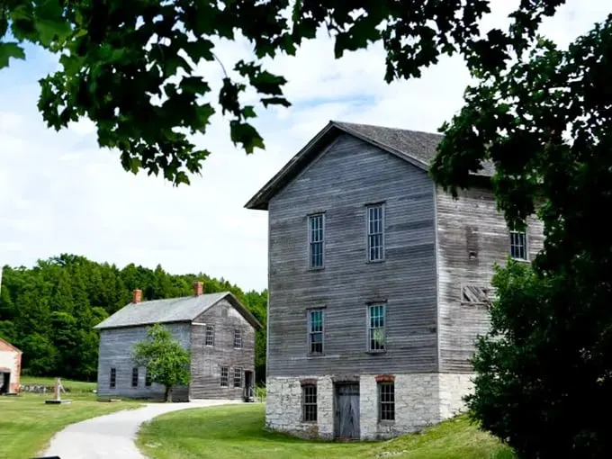 Nature's slow takeover: Fayette's buildings stand defiant, like stubborn time travelers refusing to leave the past. Photo credit: Great Lakes Explorer