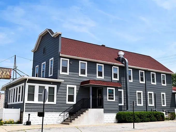 Fricano's gray-and-red exterior stands like a proud pizza sentinel, its vintage charm hinting at decades of delicious history within. Photo credit: Fricano's Pizza Tavern