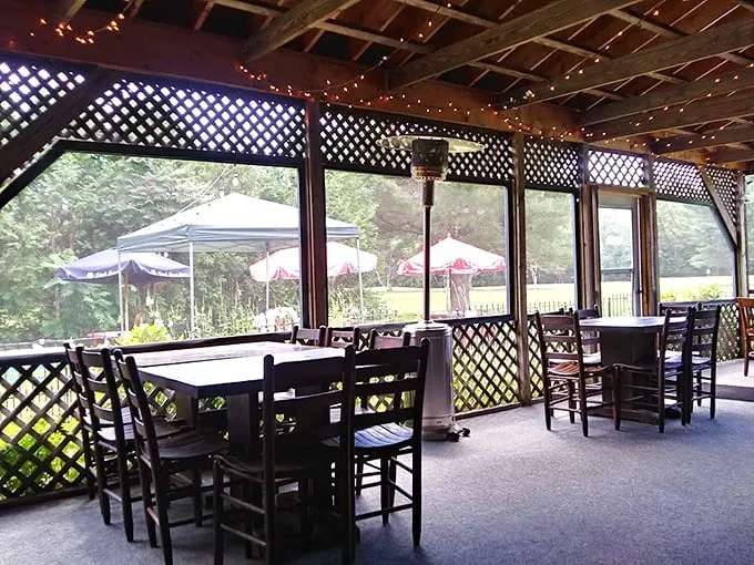 String lights twinkle above the screened porch, where diners enjoy forest views and fresh air with their craft brews. Photo credit: dan tirrell