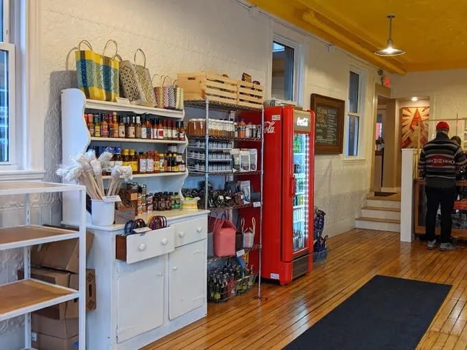 A retro Coca-Cola machine adds a pop of red to this charming market area, where shelves brim with local goodies and culinary treasures. Photo credit: Rebecca Steinberg
