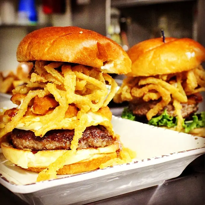 Behold the tower of temptation! This burger stack is so tall, it needs its own area code. Crispy onions crown this beefy masterpiece.