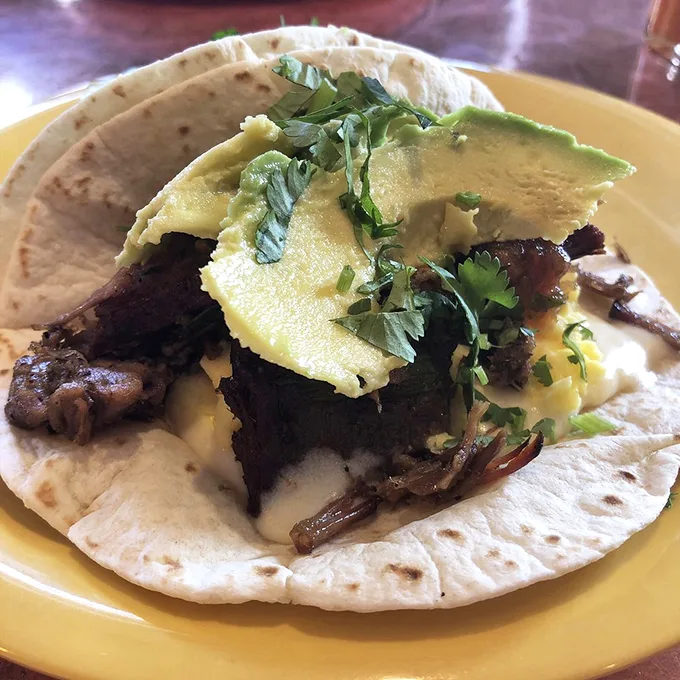 This isn't just a brisket taco – it's a love letter to Texas wrapped in a tortilla, crowned with perfectly ripe avocado. Photo credit: Andrew V.