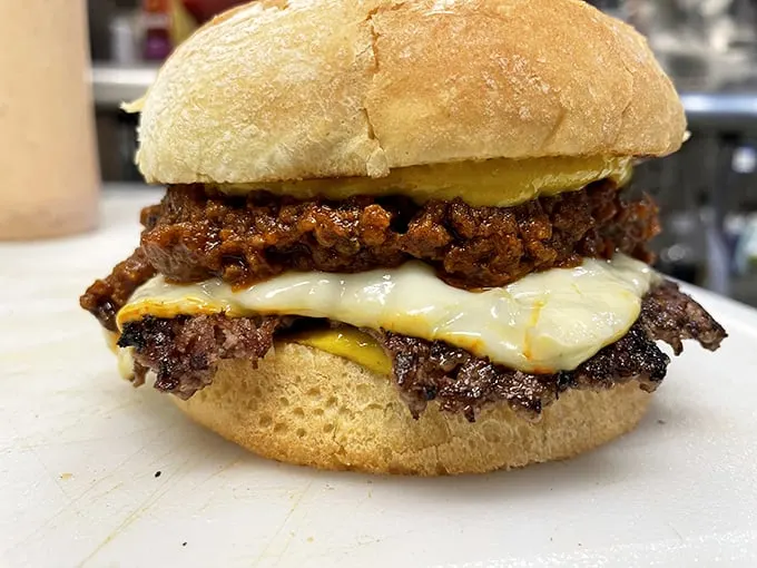 House-made chili and melted cheese create a symphony of flavors that would make any burger lover weak in the knees.