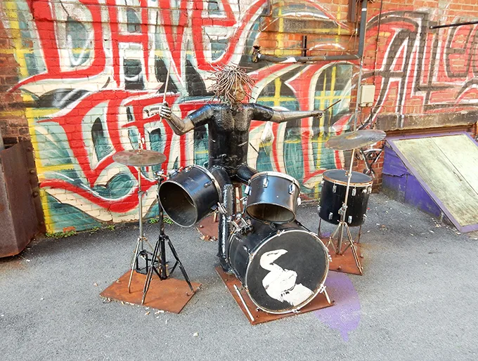 Meet the alley's guardian! This metal maestro keeps the beat alive 24/7, never missing a cymbal crash or snare hit.