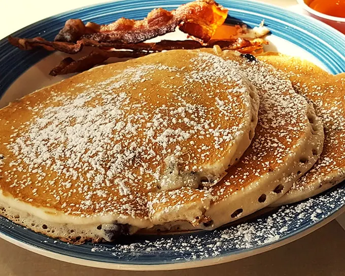 Feast your eyes on the breakfast of champions – fluffy pancakes and crispy bacon that would make even Ron Swanson weep with joy.