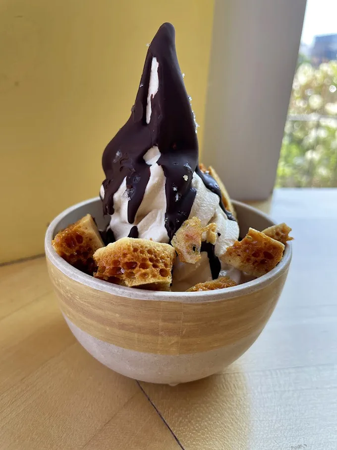 Soft serve ice cream gets dressed up for a night out with honeycomb and dark chocolate, proving dessert can be both playful and sophisticated. Photo credit: Alison Turnbull
