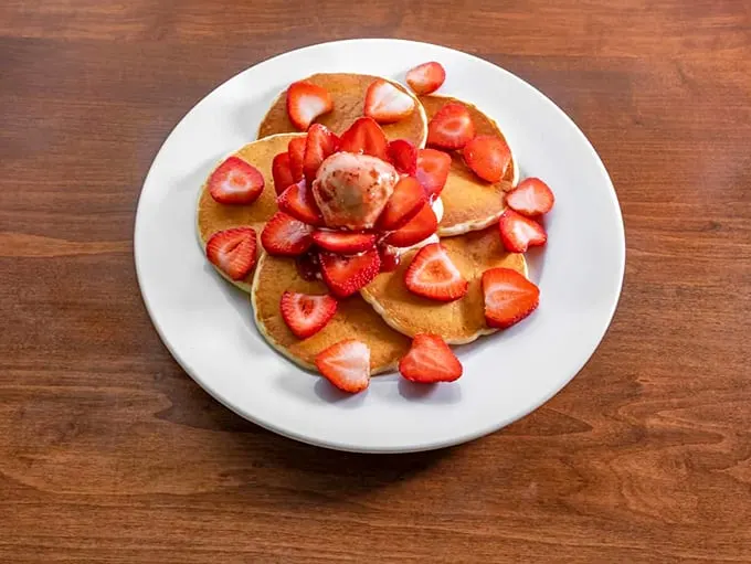 Pancakes blooming with strawberries – it's like spring decided to crash your breakfast party.