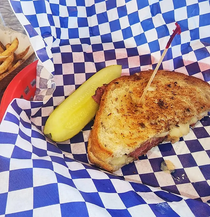 Behold, the Reuben in all its glory! Layers of corned beef and sauerkraut nestled between golden-grilled bread – it's like a warm hug for your taste buds.