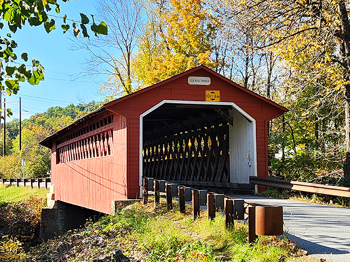 Step into a time machine, folks! This vibrant red gateway isn't just a bridge—it's a portal to Vermont's charming past.