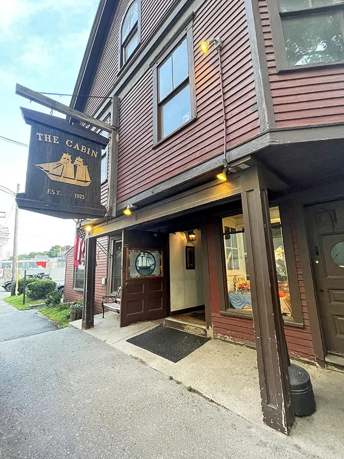 Ahoy, food lovers! The Cabin's weathered sign promises a voyage of flavor, with its golden ship sailing through time since 1973.