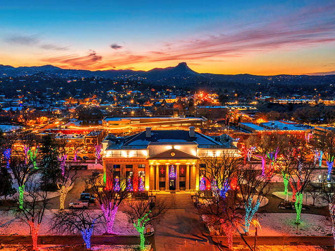 Prescott's skyline at sunset: Where the Wild West meets Christmas magic. Thumb Butte stands guard as twinkling lights paint the town in festive cheer.