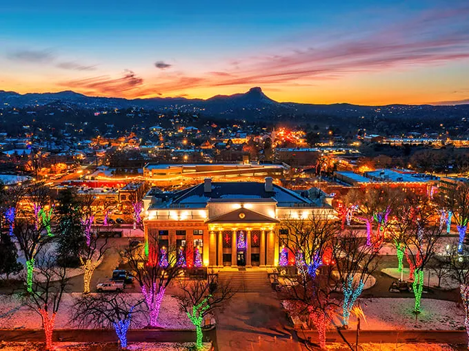 Prescott's skyline at sunset: Where the Wild West meets Christmas magic. Thumb Butte stands guard as twinkling lights paint the town in festive cheer.