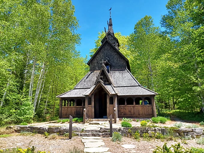 A woodland wonder! This Norse-inspired church stands tall, its dark wood a striking contrast against the vibrant green foliage. Middle Earth meets the Midwest in this architectural marvel.