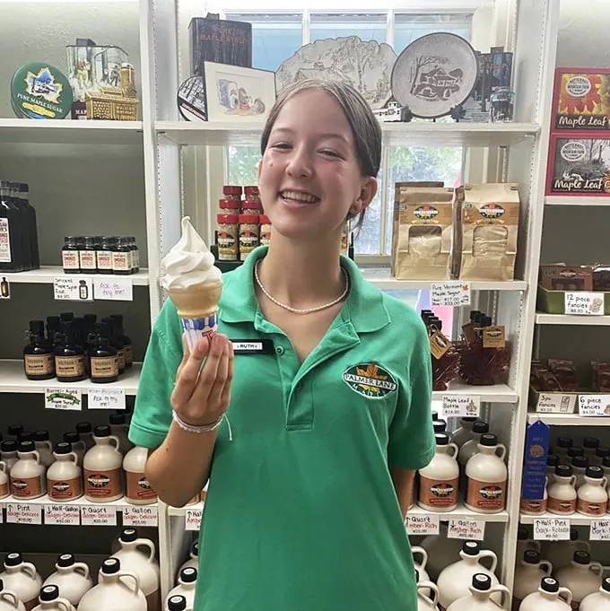 Smile and say "Creemee"! This cheerful staff member is serving up joy one cone at a time.