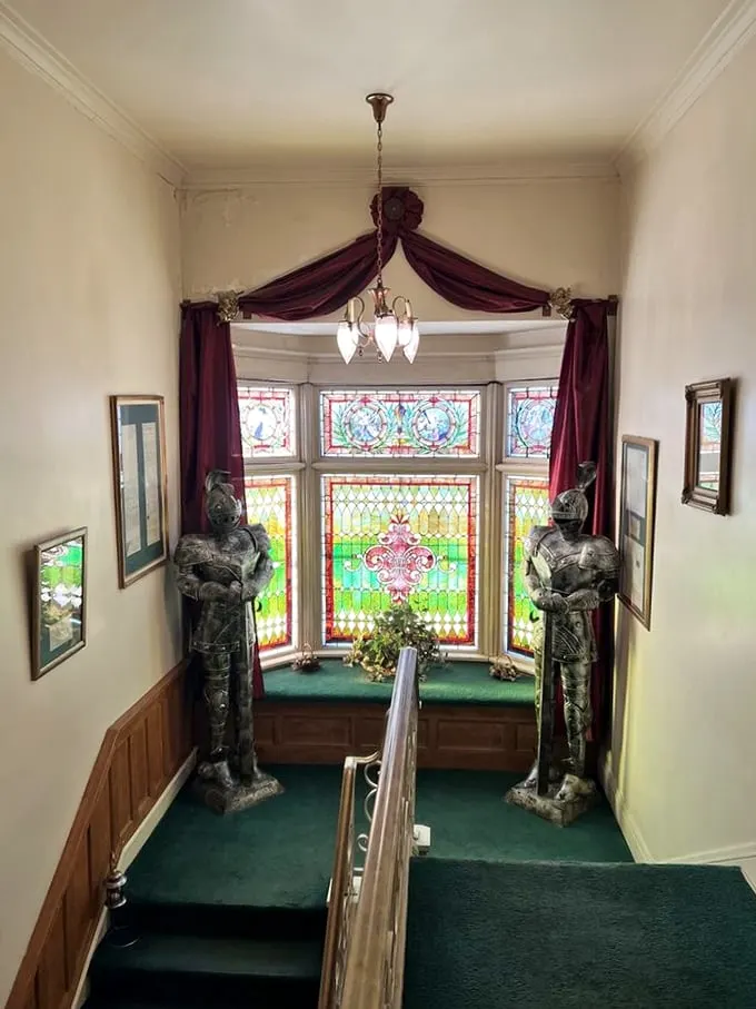 Guard your steps! These knightly sentinels flank a stunning stained-glass window. Talk about a grand entrance!