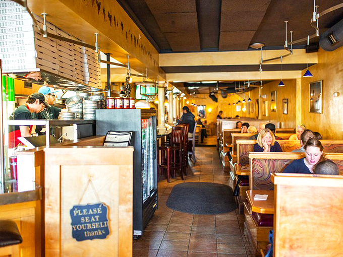 "Where pizza dreams come true." The cozy interior invites you to settle in for a feast, with warm wood tones and the irresistible aroma of fresh-baked goodness.