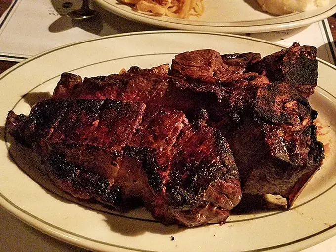 Holy cow! This Porterhouse steak is so massive, it might need its own ZIP code. Perfectly charred on the outside, pink on the inside – it's meat nirvana.