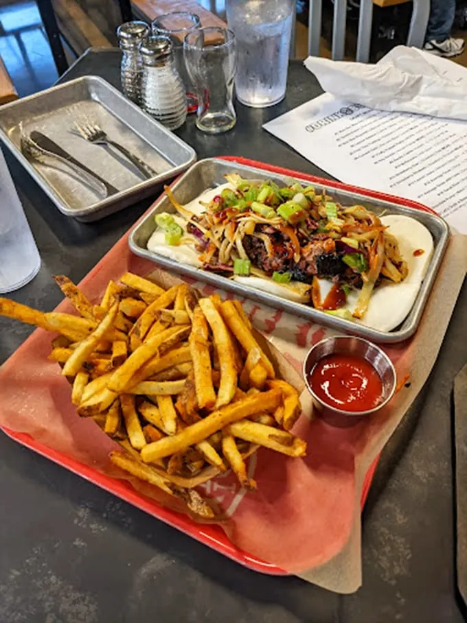 Behold, the pulled pork sandwich in all its glory! It's like a meaty hug between two buns, ready to transport you to flavor town.