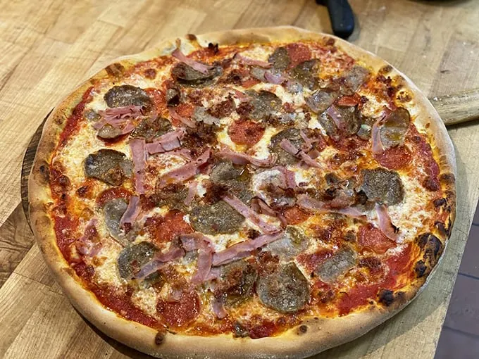 "Meat lover's paradise on a crust." This pizza is so loaded with toppings, it's practically doing bicep curls. A carnivore's dream come true!