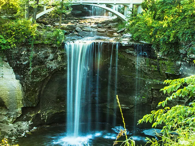 Nature's own waterfall selfie! Minneopa Falls cascades with the grace of a Hollywood starlet, framed by a picturesque bridge and lush greenery.