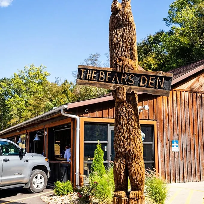 Welcome to the woods! The Bear's Den Steakhouse greets you with rustic charm and a wooden bear that's begging for a selfie.