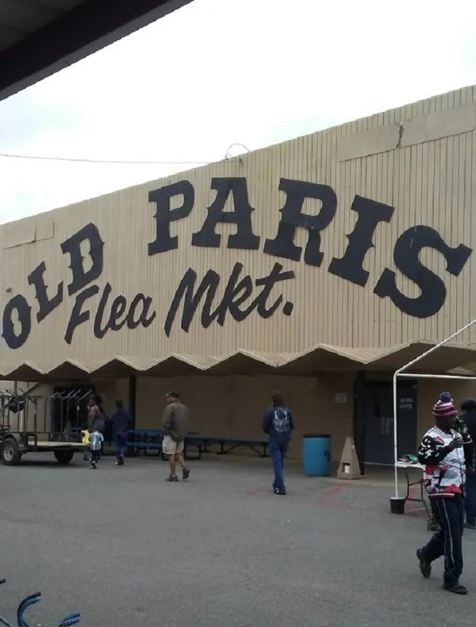 Welcome to the treasure hunter's paradise! Old Paris Flea Market beckons with its retro sign, promising a labyrinth of curiosities and bargains inside.