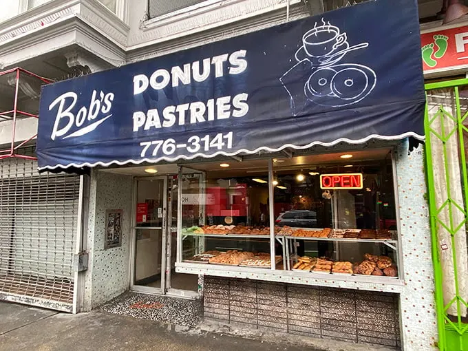 Welcome to donut paradise! Bob's blue awning beckons like a siren song, promising sweet delights 24/7. Resistance is futile, my friends.