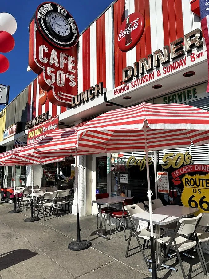 Welcome to the land of sock hops and soda jerks! Cafe 50's exterior screams "American Graffiti" come to life, with its bold red-and-white stripes and neon signs promising a trip down memory lane.