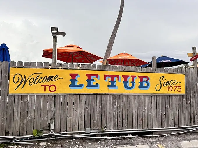 Welcome to Le Tub, where tropical vibes meet culinary magic! This weathered wooden fence guards a treasure trove of flavor and quirky charm.