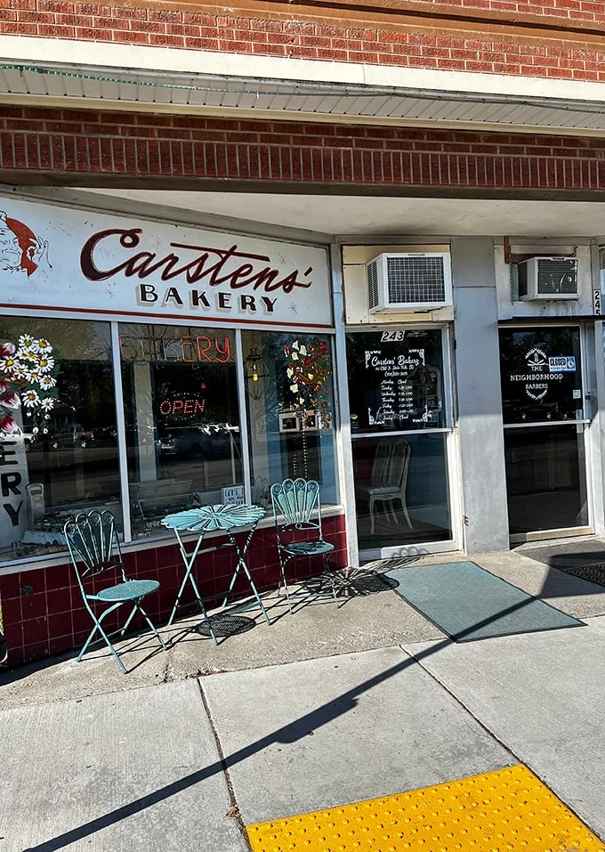 Welcome to carb heaven! This unassuming brick facade hides a treasure trove of baked delights, crowned by a giant pretzel sign that's basically a bat-signal for pastry lovers.