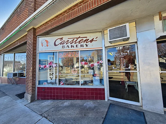 Welcome to carb heaven! This unassuming brick facade hides a treasure trove of baked delights, crowned by a giant pretzel sign that's basically a bat-signal for pastry lovers.