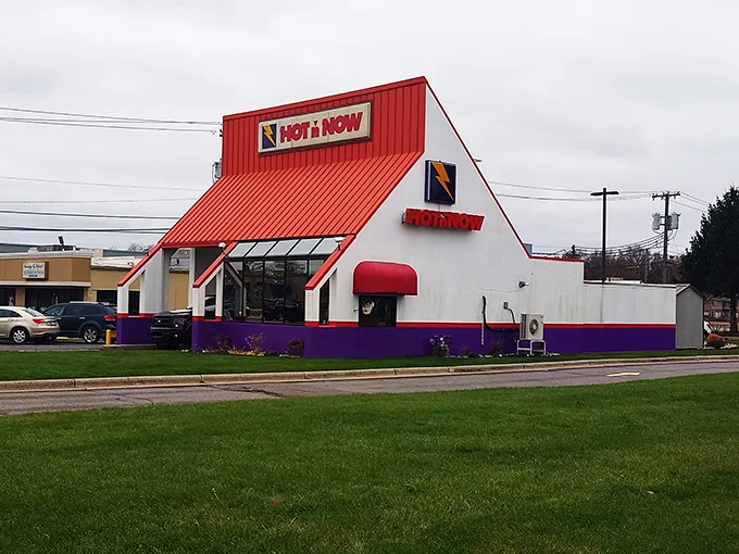 A beacon of burger bliss! Hot 'n Now's iconic red roof and retro charm beckon hungry travelers like a neon-lit oasis in the fast food desert.