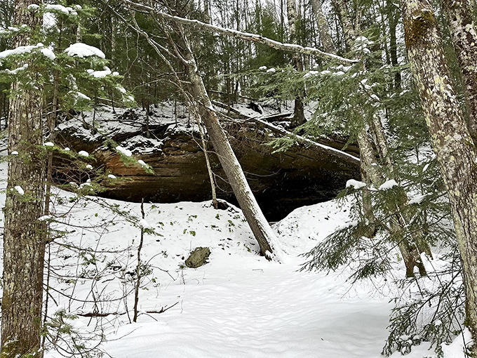 Winter's secret hideaway: Snow-covered rocks create a cozy nook, perfect for hibernating bears or adventurous humans seeking solitude.