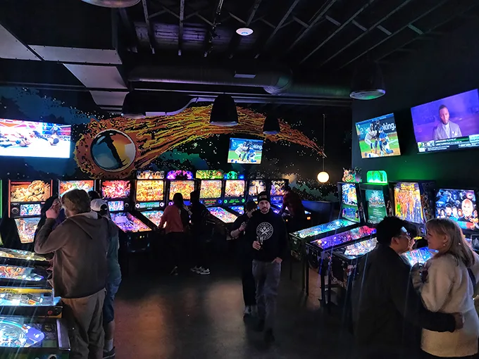 A row of pinball machines standing at attention, each one a portal to a different world of flippers and bumpers.