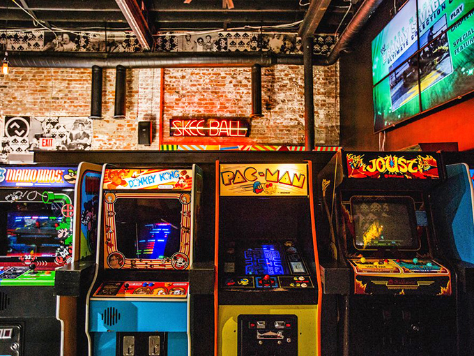 Classic arcade cabinets lined up like soldiers, ready for battle. Each one a portal to a simpler time when 'social network' meant gathering around the high score screen.
