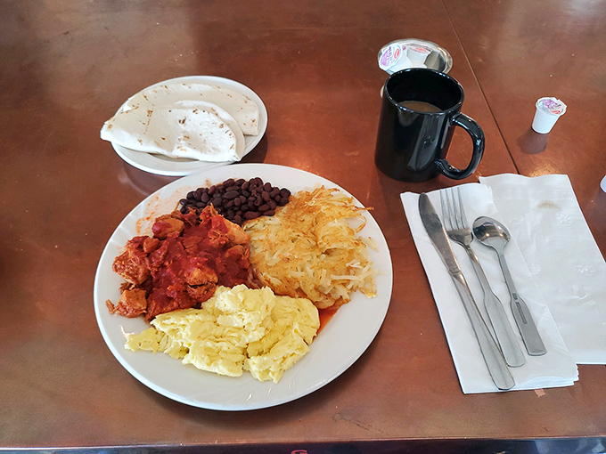 A plate that screams "New Mexico" louder than a coyote howl. Red chile, beans, and eggs – the holy trinity of Southwest breakfasts.