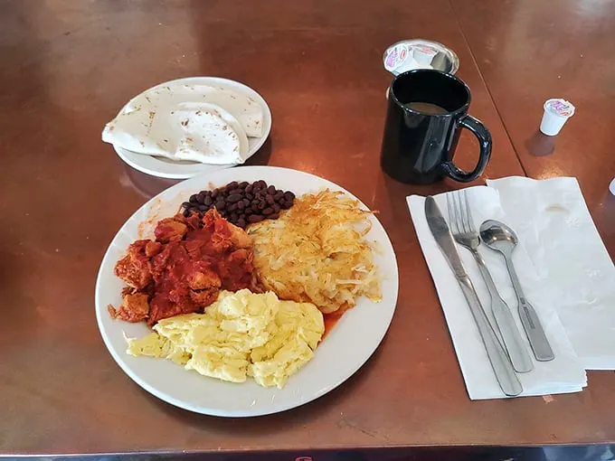 A plate that screams "New Mexico" louder than a coyote howl. Red chile, beans, and eggs – the holy trinity of Southwest breakfasts.