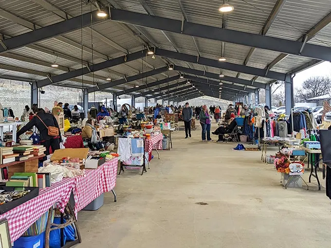 Bargain hunters navigate the covered pavilions of Nashville Flea Market, where red-checkered tablecloths stretch endlessly like a picnic gone wonderfully wild.
