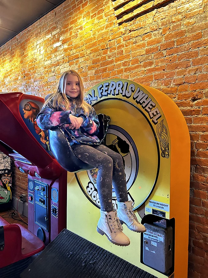 All aboard the Ferris wheel of fun! This pint-sized player proves that arcade magic transcends generations, captivating young and old alike.