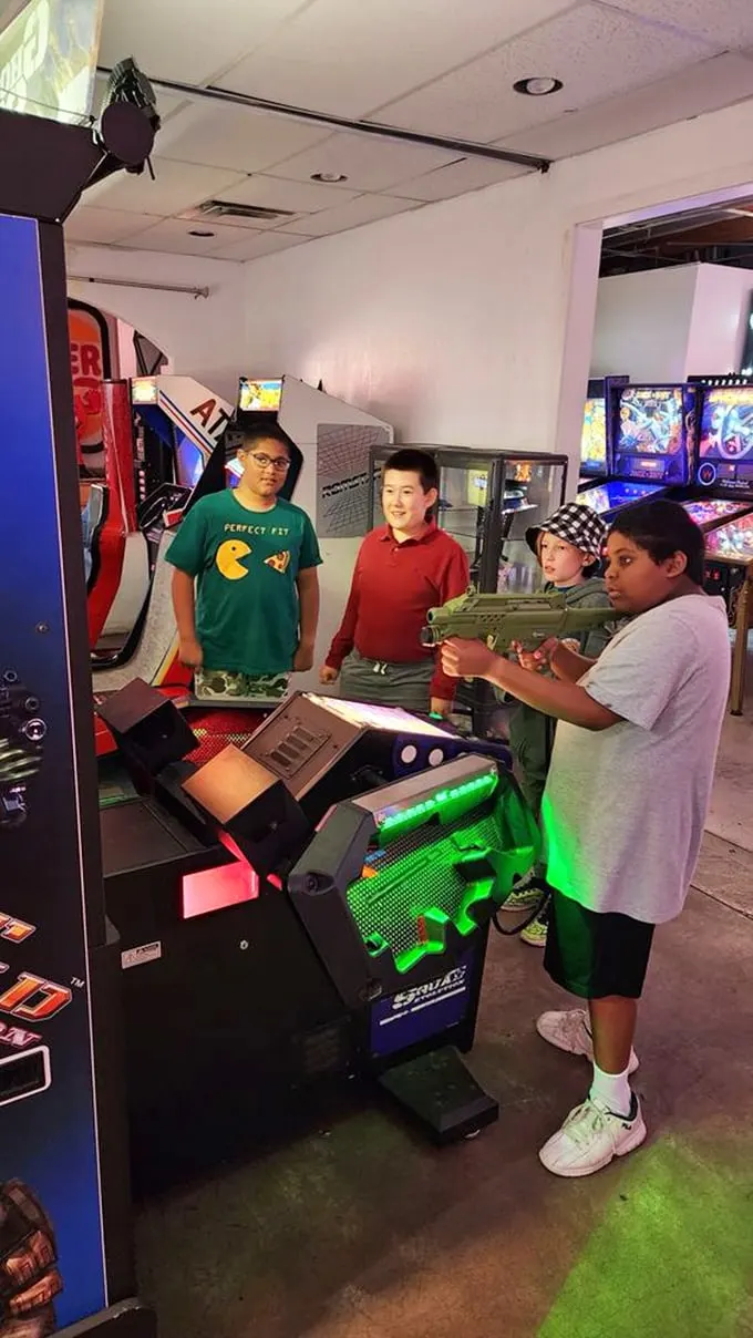 Squad goals, arcade edition. These young guns are learning the ancient art of cooperative play – and probably planning their next sugar rush.