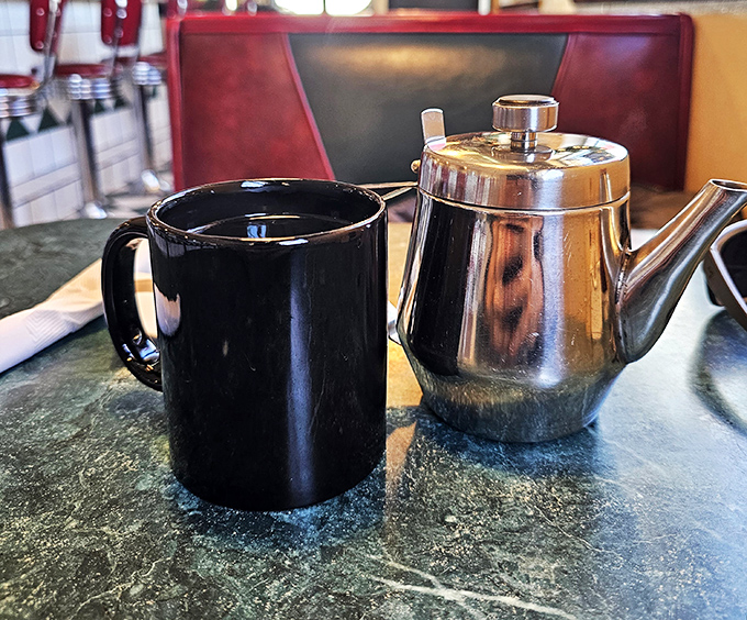 The dynamic duo of diner dining: A steaming cup of joe and a classic silver pot. Name a more iconic breakfast pair – I'll wait.