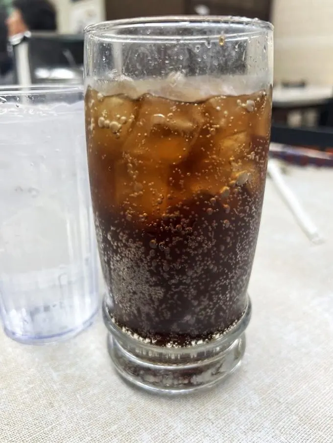 Bubbles rising like tiny elevators in a glass skyscraper. This isn't just soda, it's the perfect fizzy counterpoint to your coney adventure.