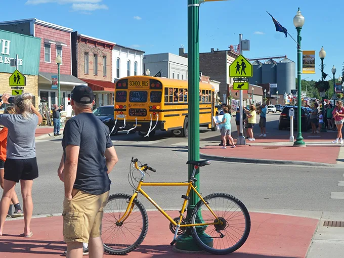 School's out for summer! This bustling street scene captures the excitement of a small town coming alive on a sunny day.