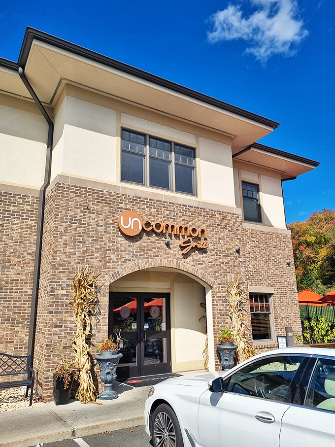 The stately brick facade of Uncommon Grill welcomes you with vibrant hibiscus flowers, promising an experience that's anything but ordinary.